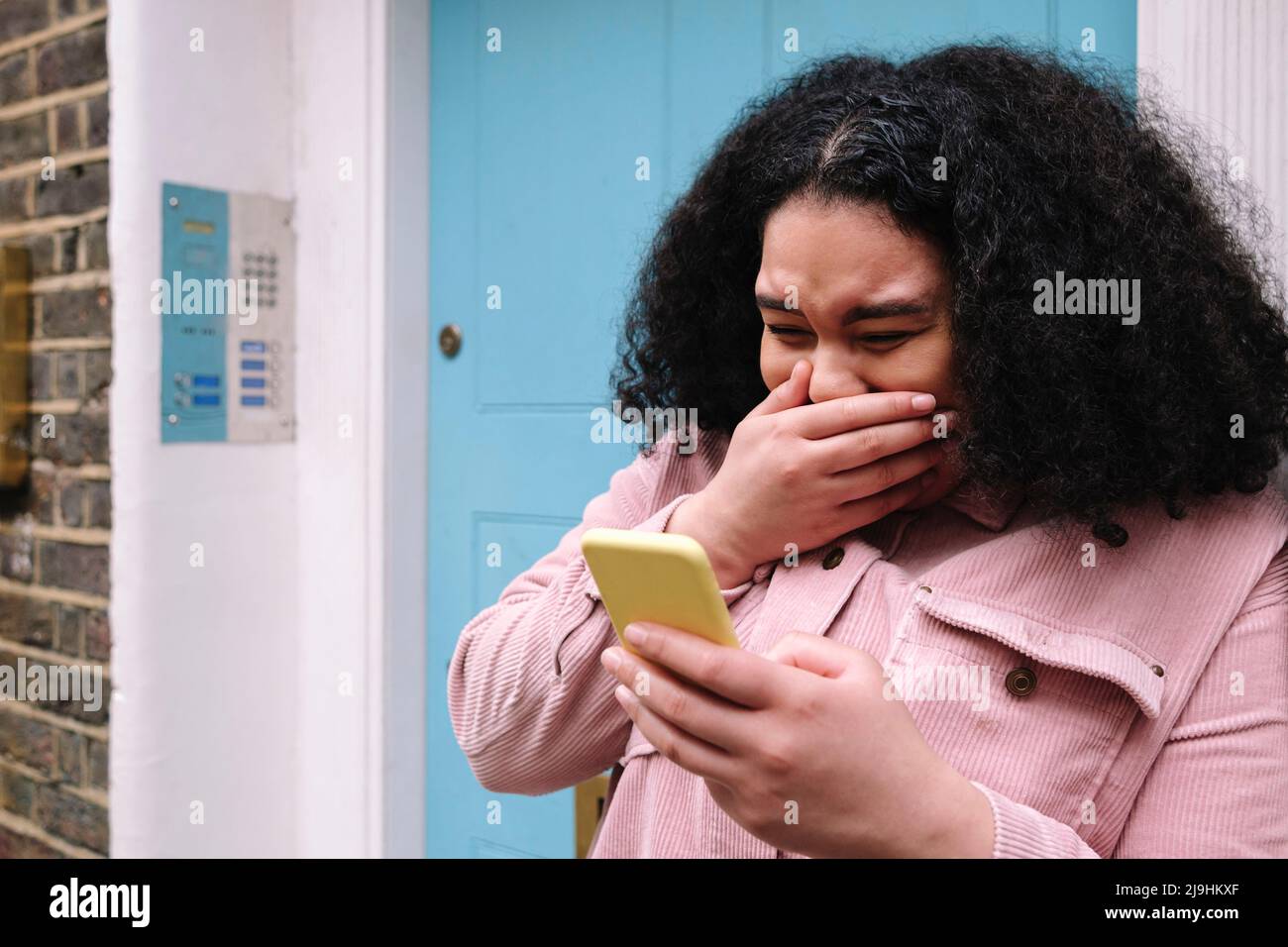 Young woman covering mouth laughing hi-res stock photography and images ...