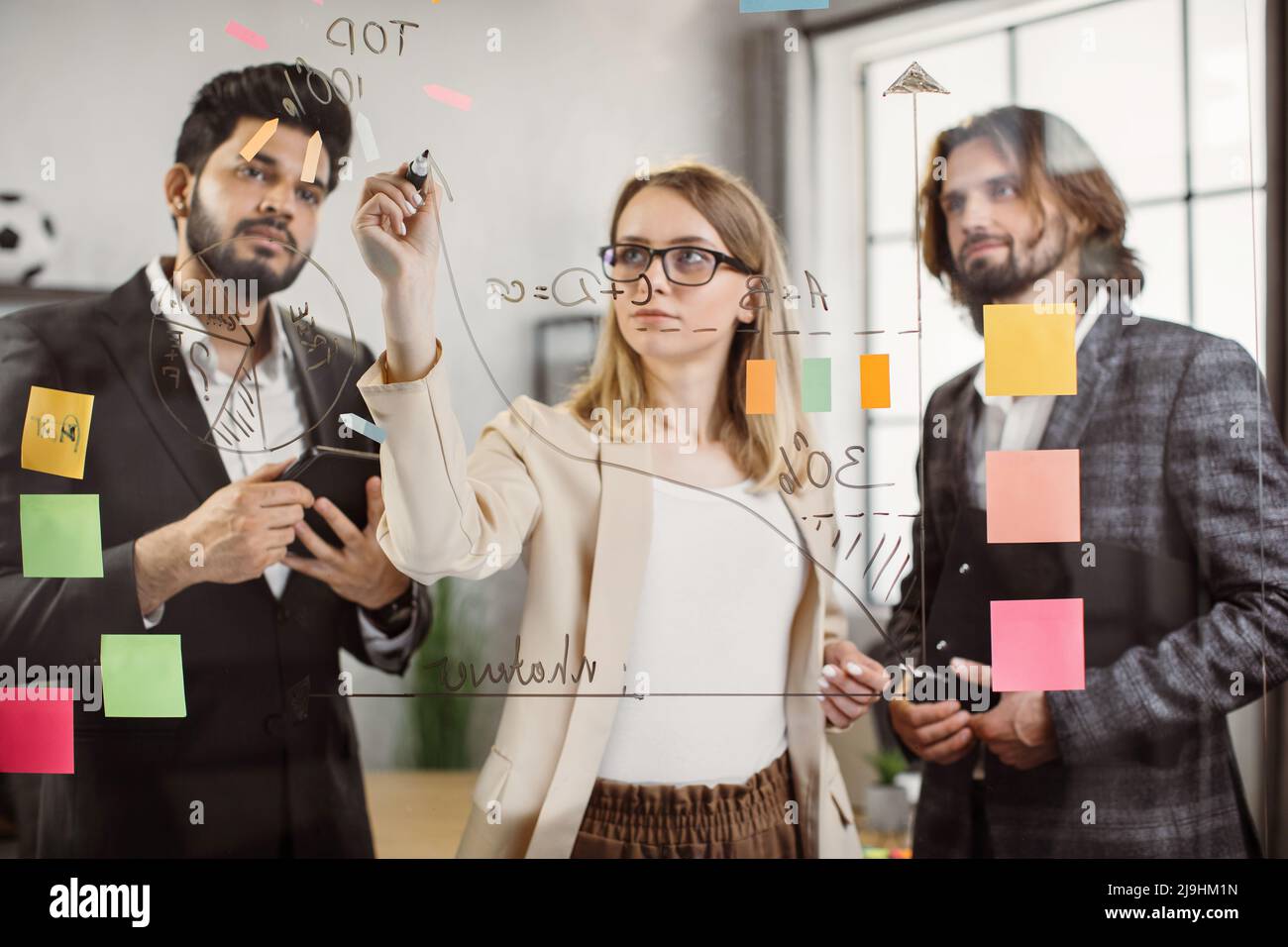 Multicultural group of young financiers in formal wear using ...