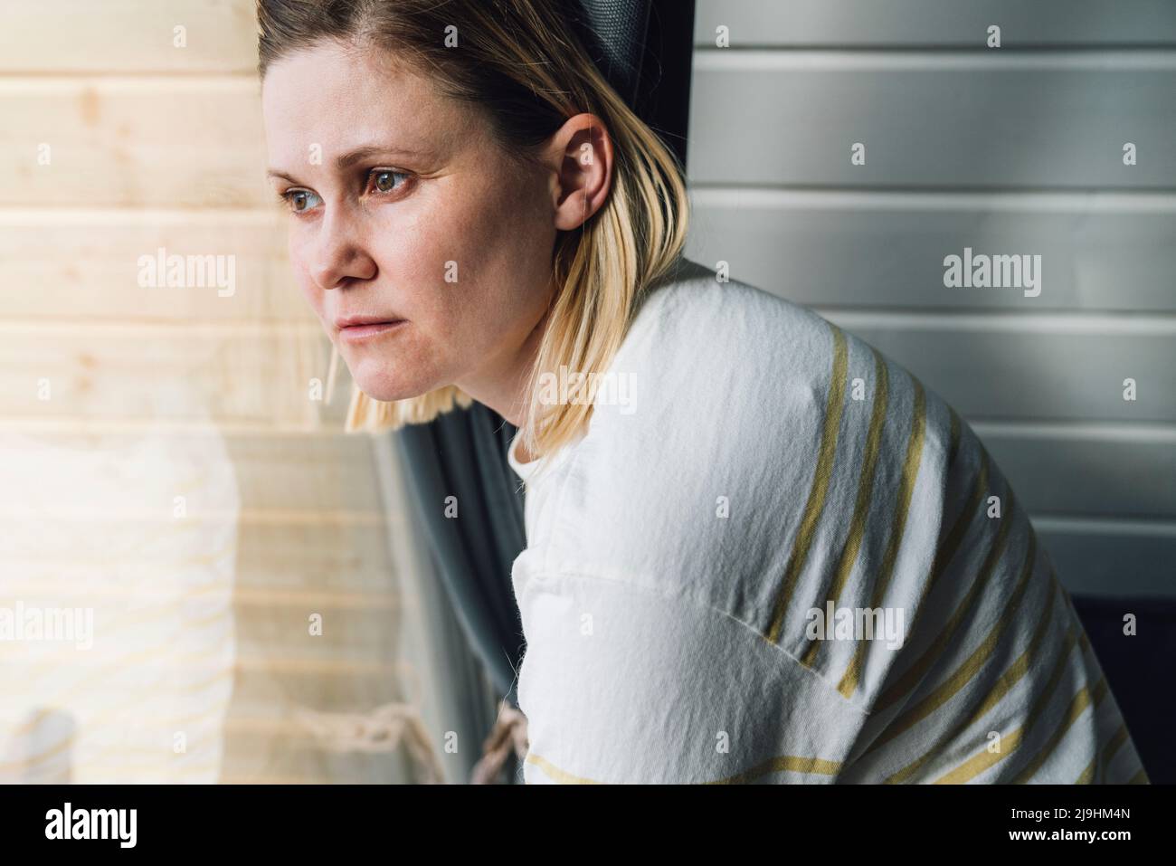 Sad woman looking out window hi-res stock photography and images - Alamy