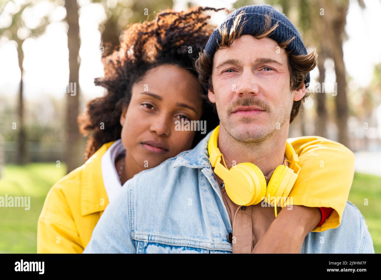 Woman with arm around boyfriend at public park Stock Photo - Alamy