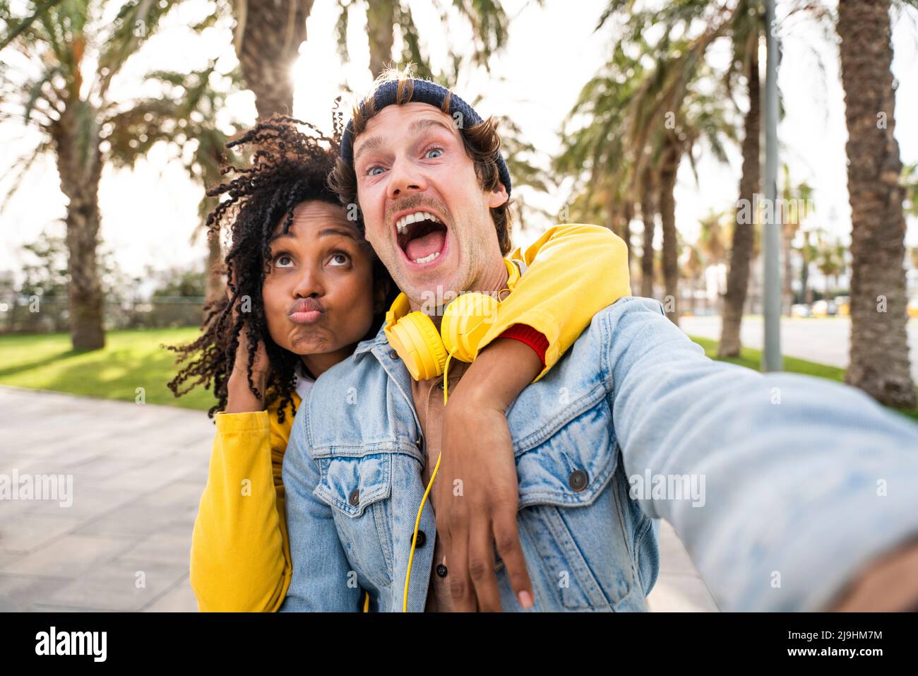 Happy man shouting by girlfriend puckering lips at park Stock Photo - Alamy