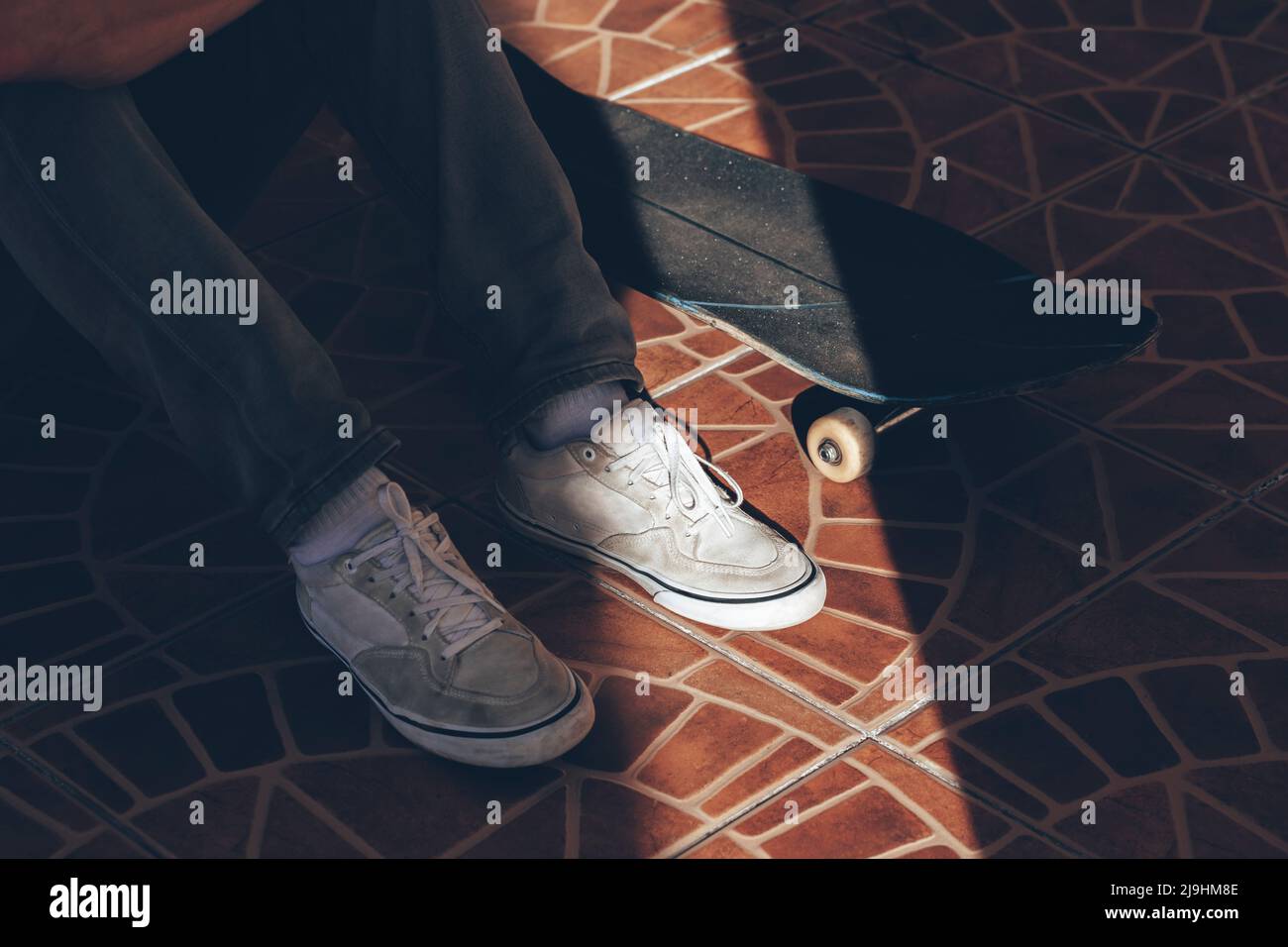 Sunlight on man's shoe and skateboard Stock Photo - Alamy