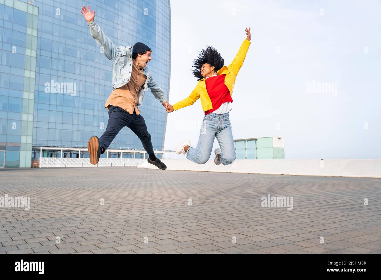 Couple holding hands jumping hi-res stock photography and images - Alamy