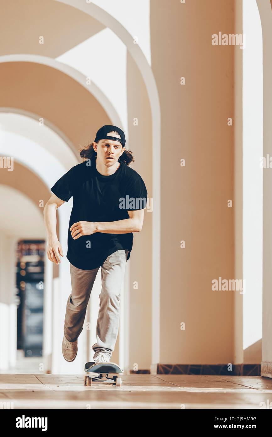 Man skateboarding in arcade Stock Photo - Alamy
