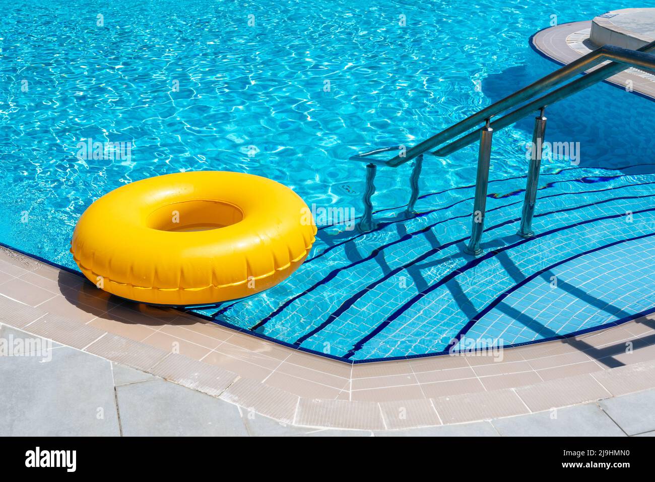Yellow ring floating in refreshing blue swimming pool Stock Photo - Alamy