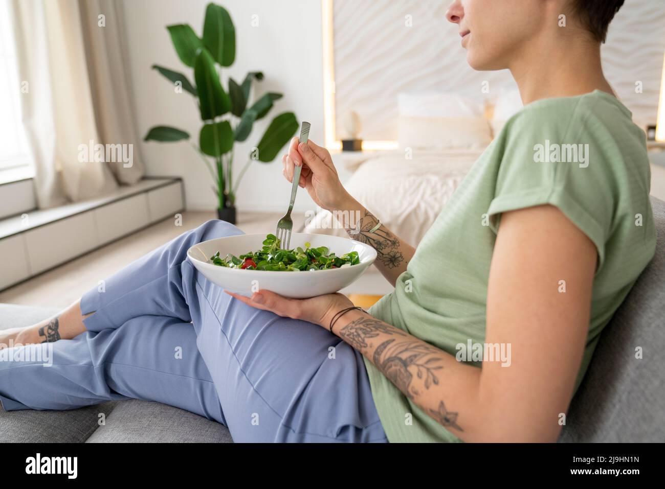 Woman eating salad sofa hi-res stock photography and images - Alamy