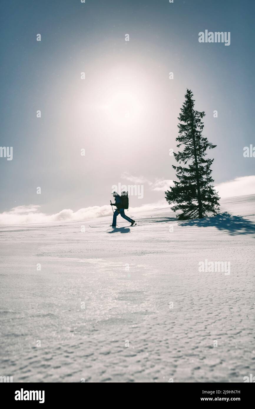 Norway, Gjevsjoen, Sun shining over silhouette of lone hiker trudging ...