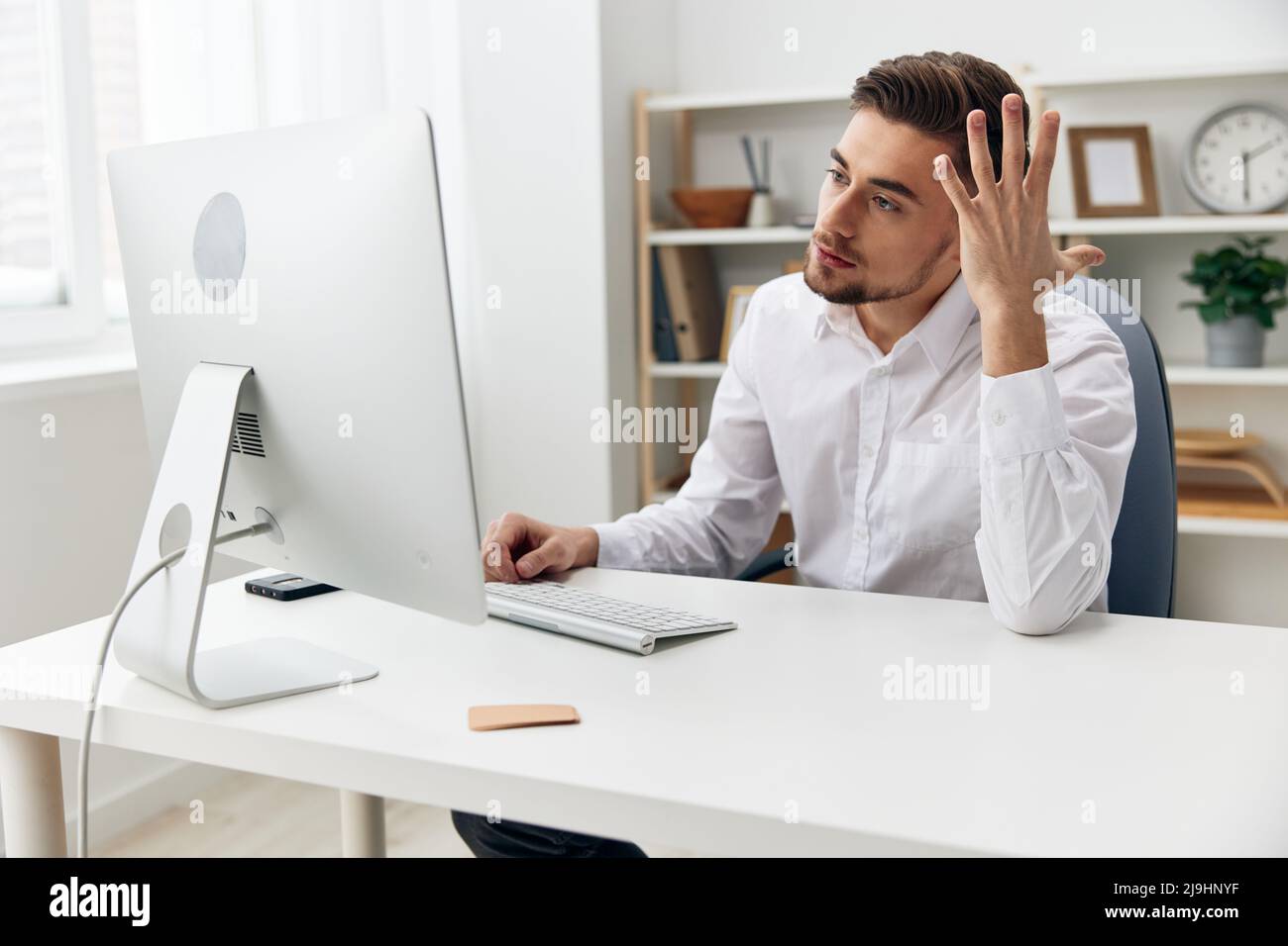 manager sitting at a desk in front of a computer with a keyboard ...