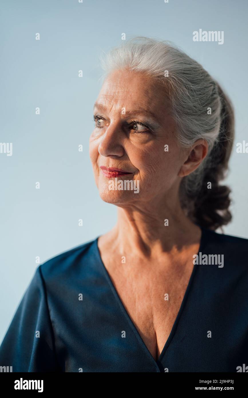 Senior woman standing against white background Stock Photo - Alamy