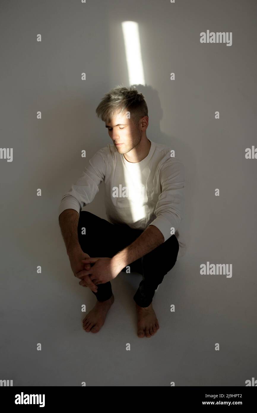 Stressed young man with beam of light on face Stock Photo - Alamy