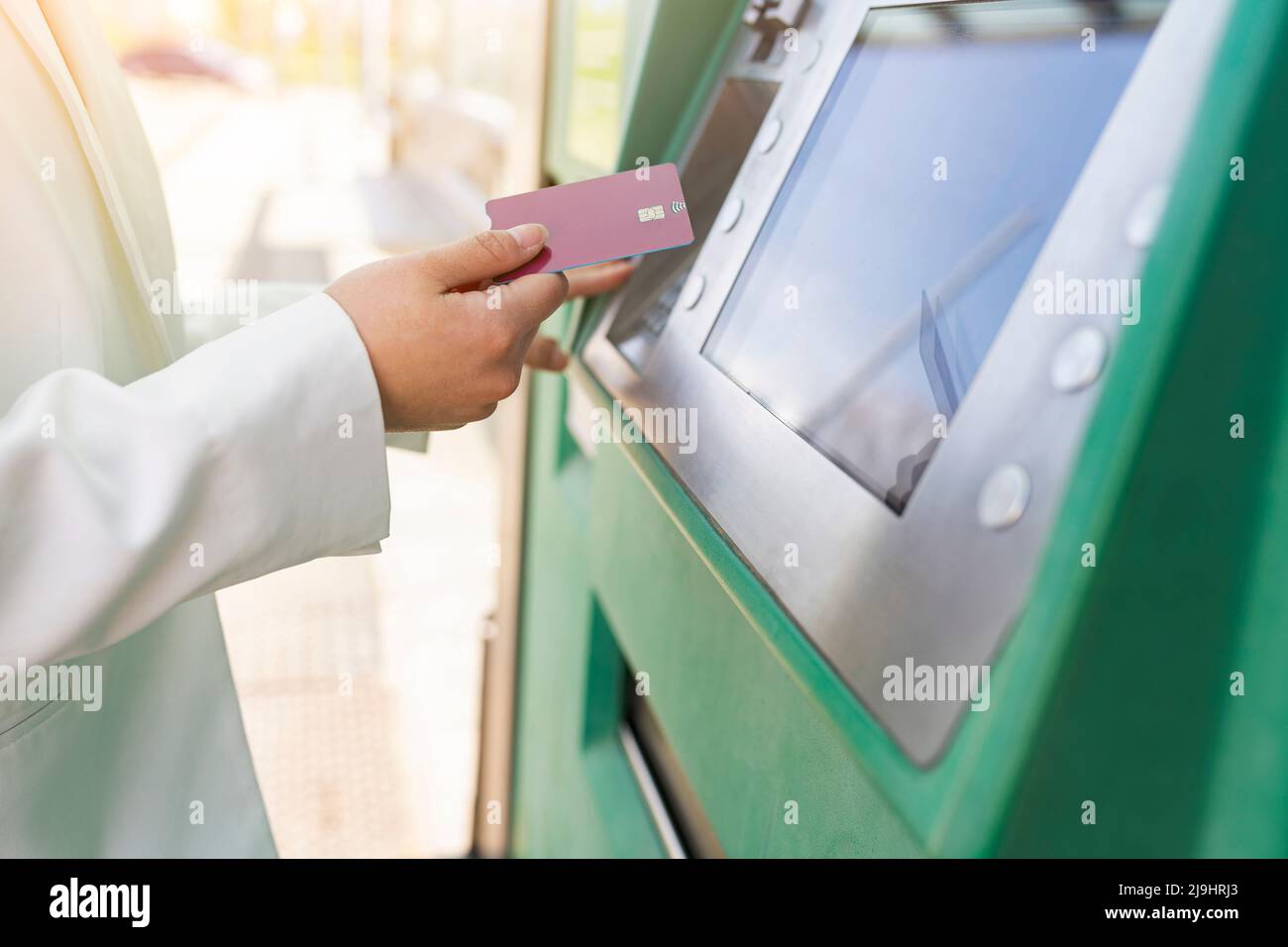Hand of businesswoman holding credit card buying ticket at tram station ...