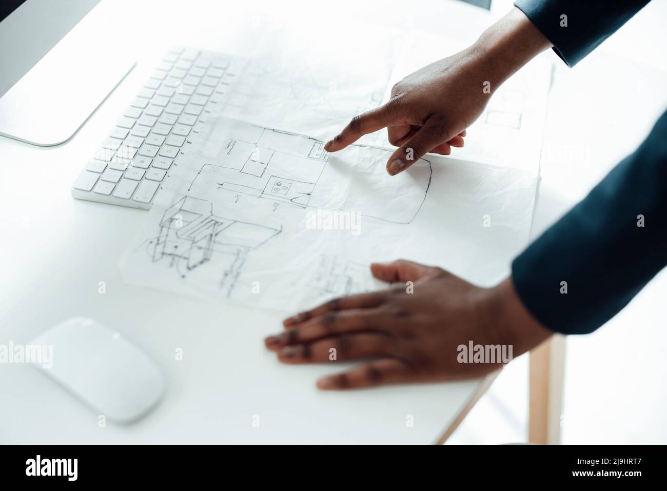 Hand of architect pointing on blueprint at desk Stock Photo - Alamy