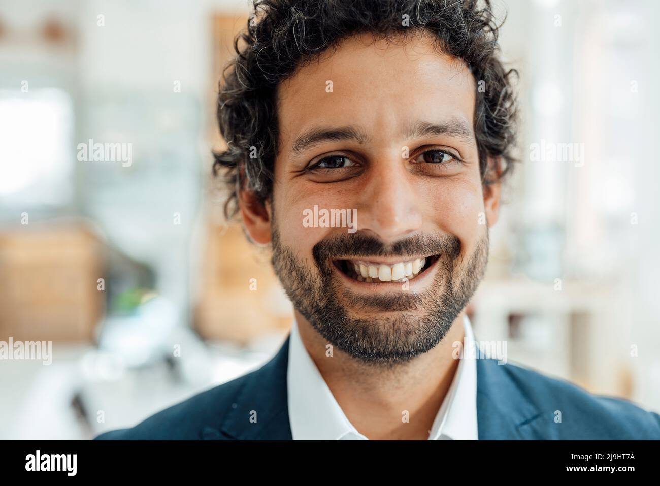 Happy businessman standing in office Stock Photo - Alamy