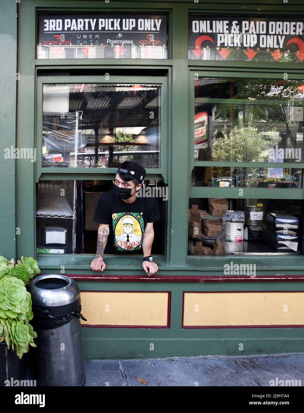 An employee of Tony's Pizza Napoletana peers outside the restaurant's ...