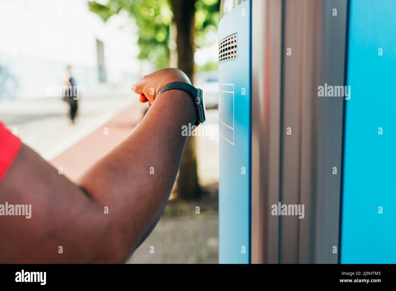 Hand of woman with smart watch using tap to pay method at ticket ...