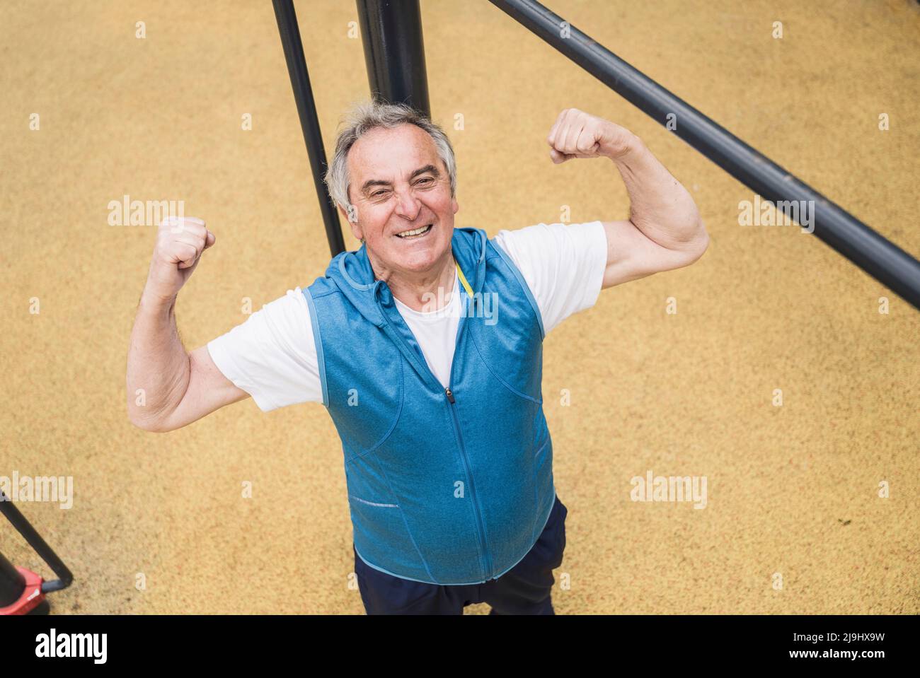 Confident senior man flexing muscles at park Stock Photo - Alamy