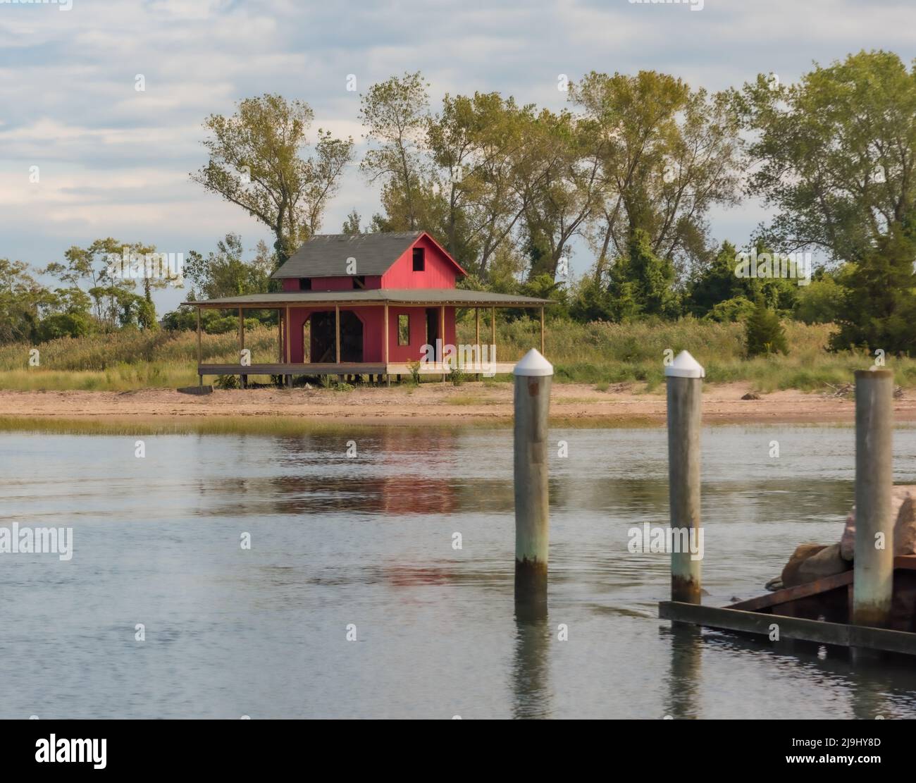 Red barn reflecting on river with pier in foreground Stock Photo - Alamy