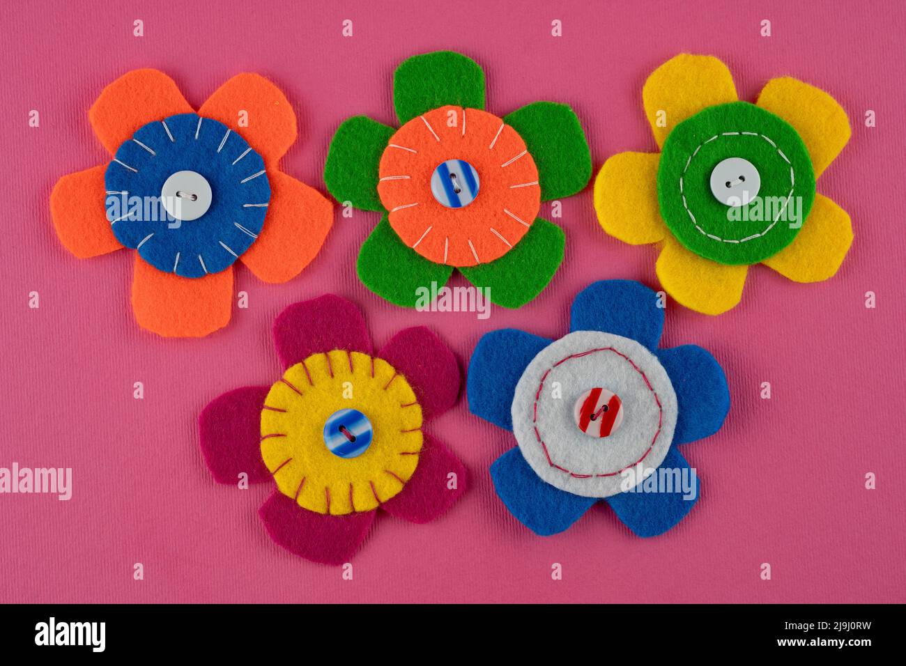 Handmade cute colorful flowers with buttons on pink background Stock ...