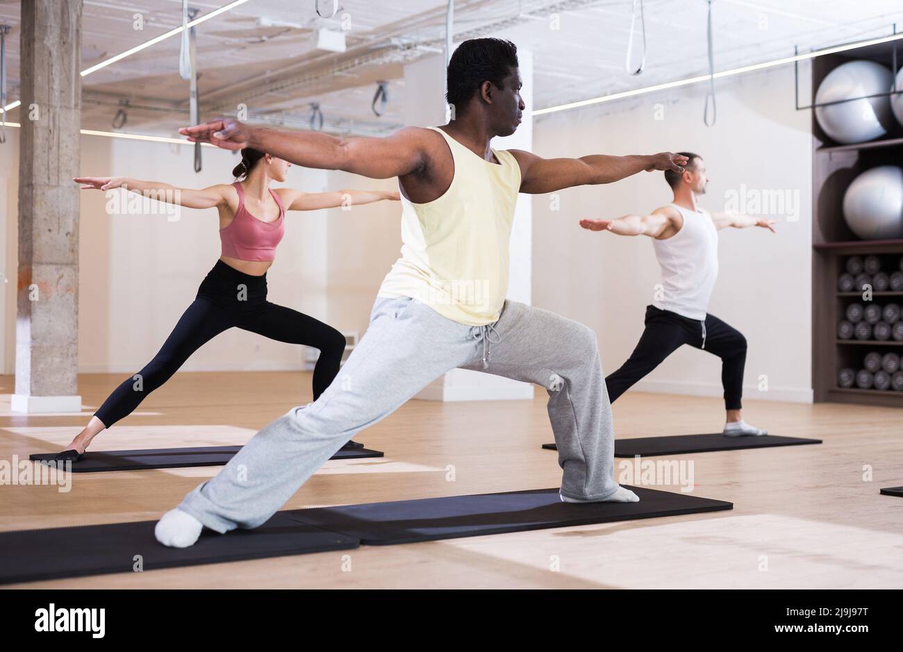 African American man doing pilates exercises with group Stock Photo - Alamy