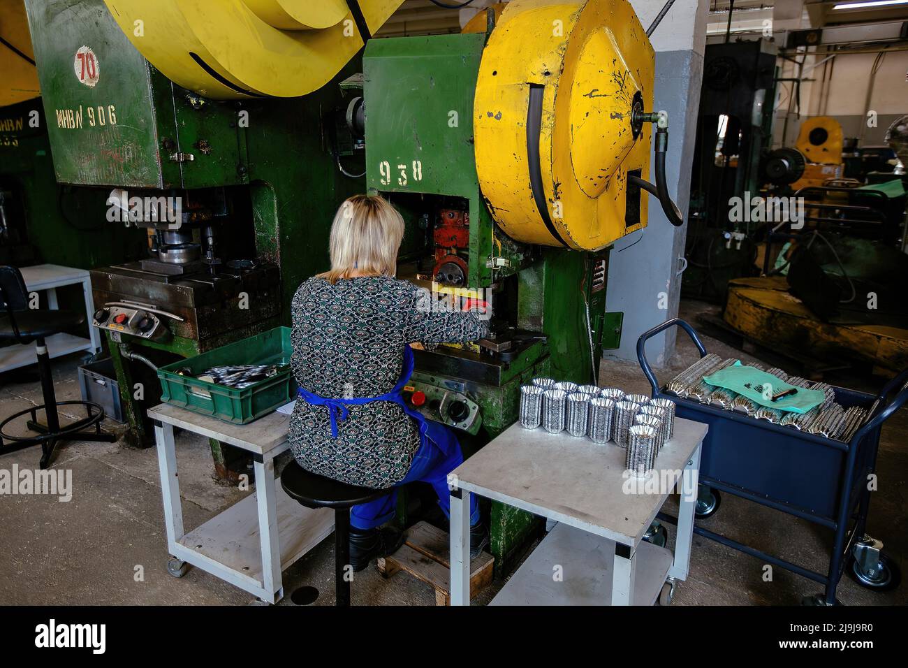 Worker operates metal press stamping machine. Production of press forms ...