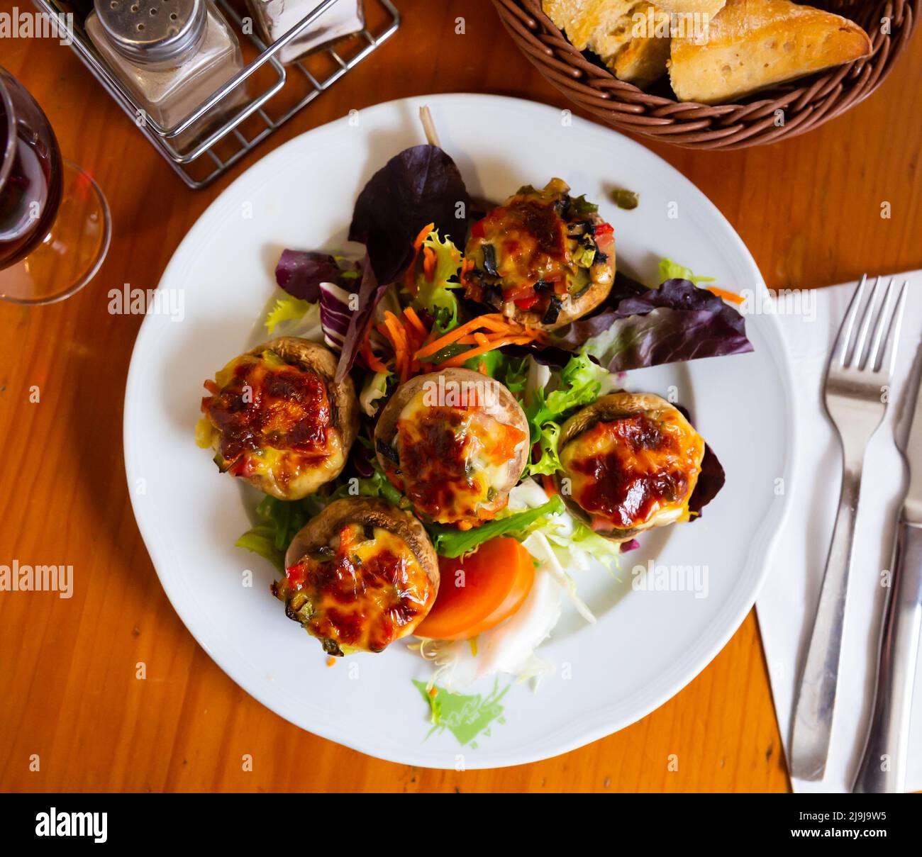 Mushrooms stuffed with vegetables and ham, baked with mozzarella Stock ...