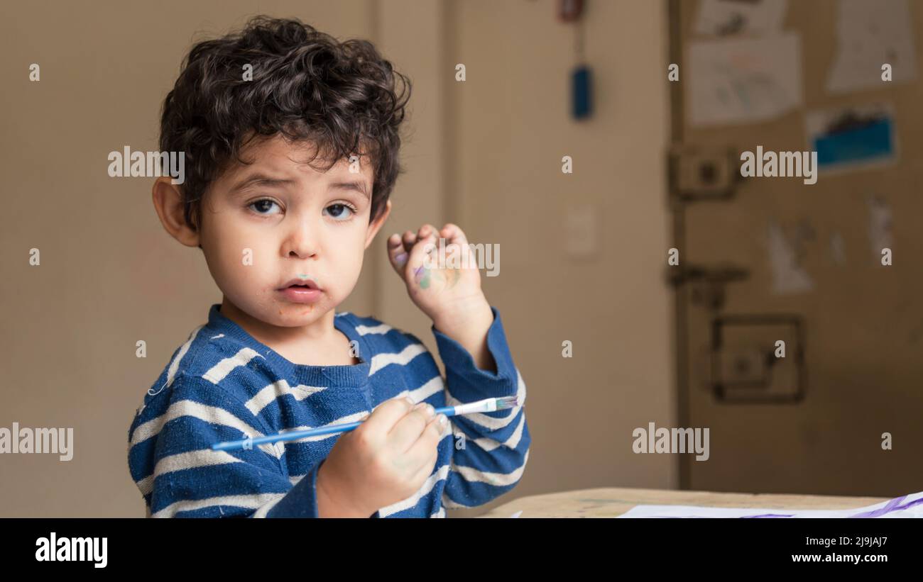 sleepy boy painting with brushes and paint Stock Photo - Alamy