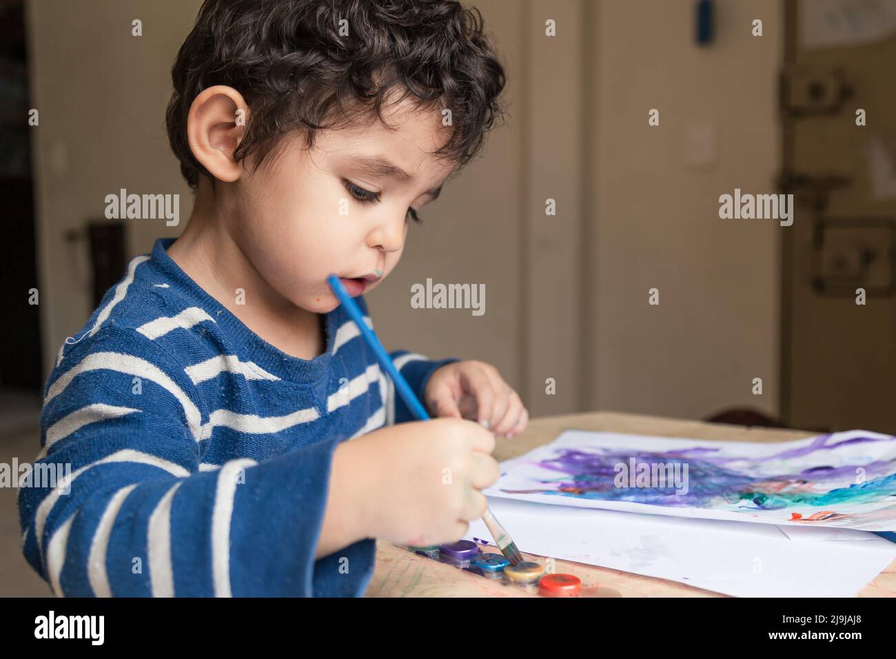 child painting with paints and colored pencil making a drawing Stock ...