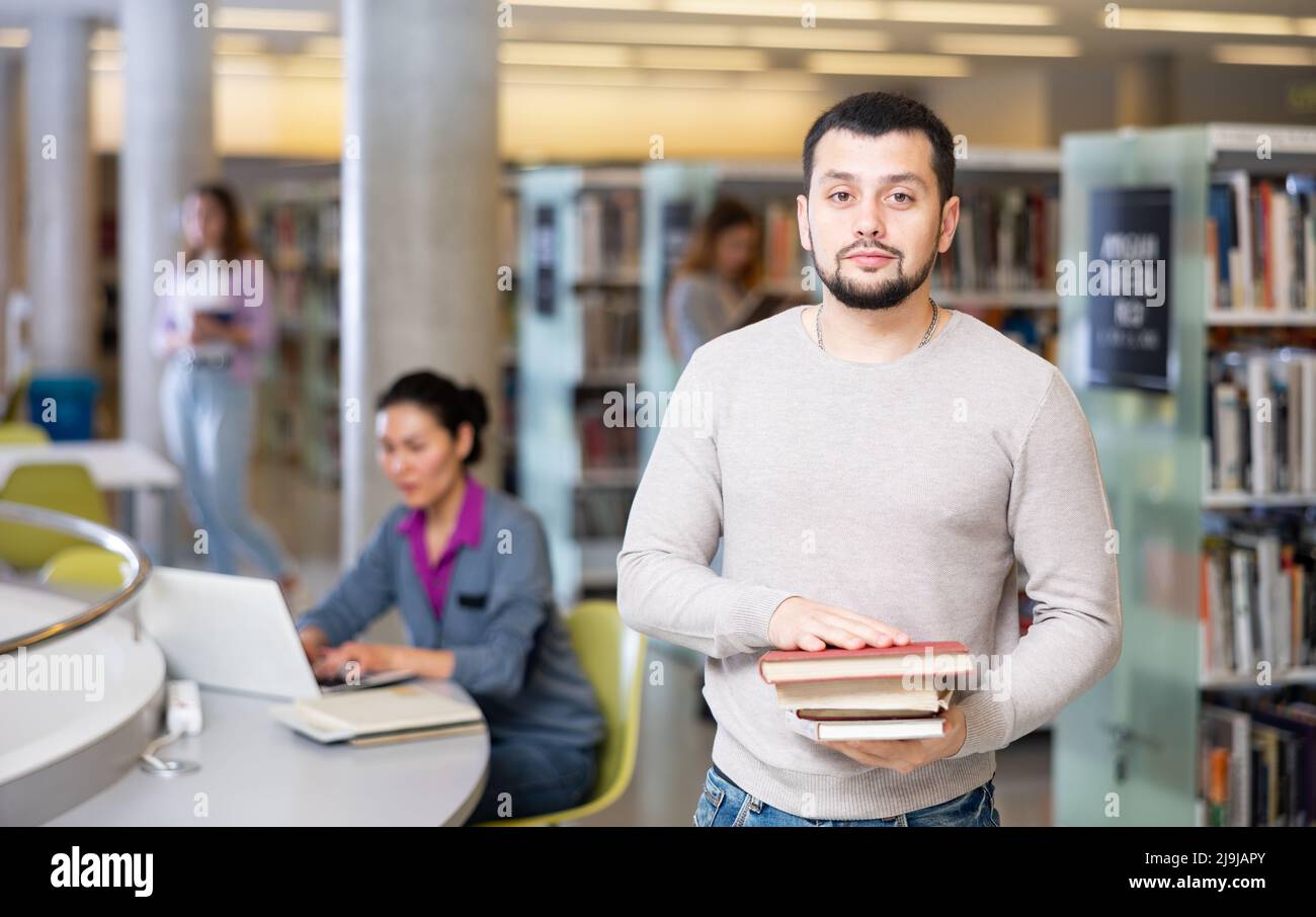 Portrait of a student guy in the library with textbooks Stock Photo - Alamy