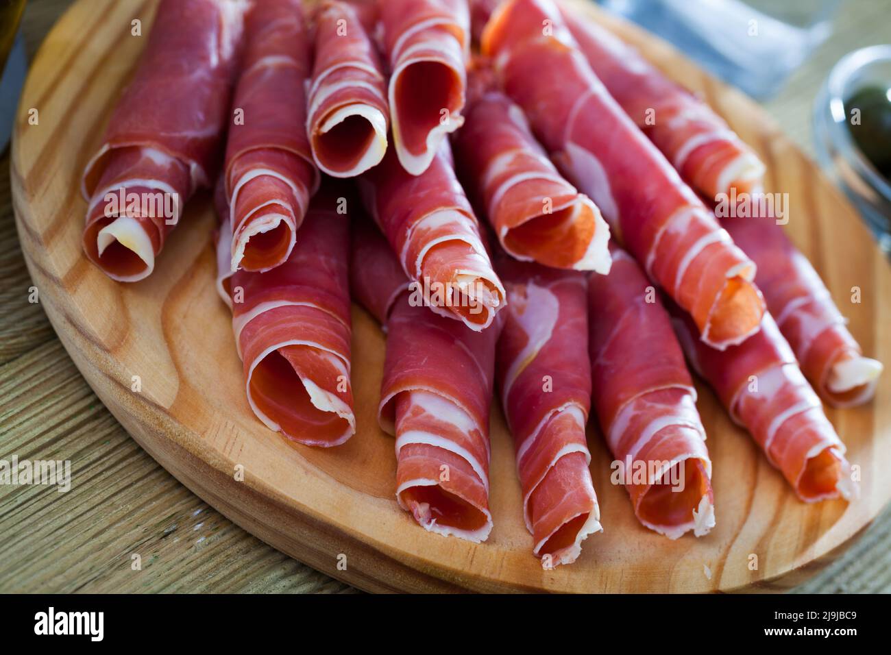 Traditional Spanish meal - rolls of iberian jamon served at plate Stock ...