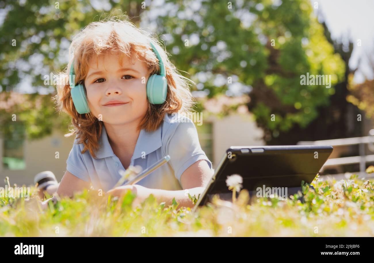Cute american toddler school boy online learning, writing book in the park. Study outdoor Stock ...