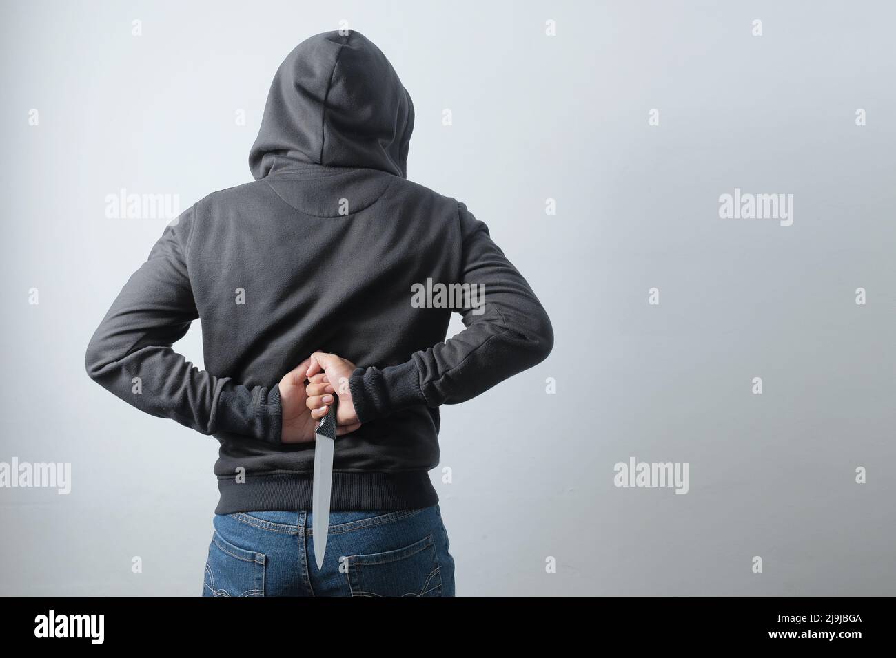 rear view mysterious man holding knife in the back Stock Photo - Alamy