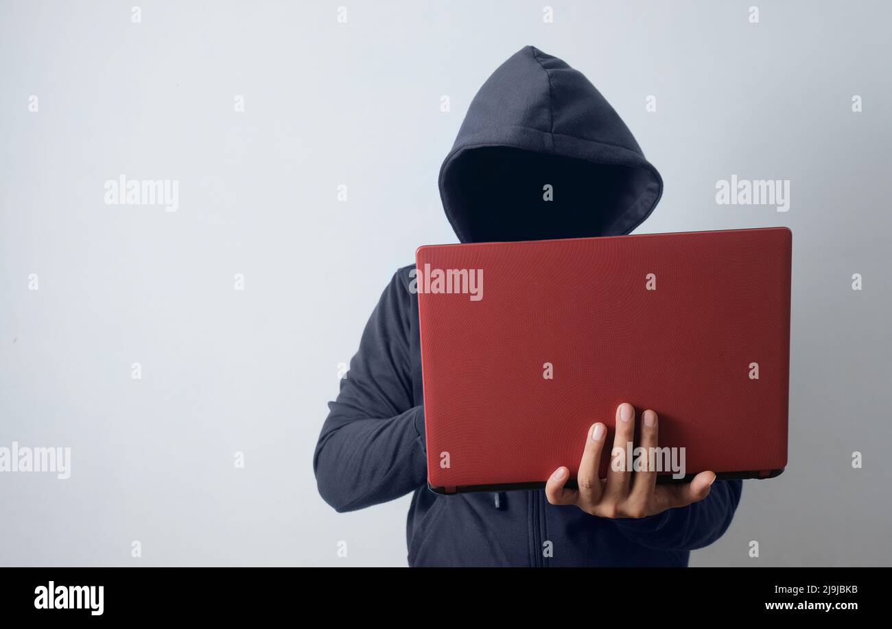mysterious man wearing hoodie holding laptop Stock Photo - Alamy