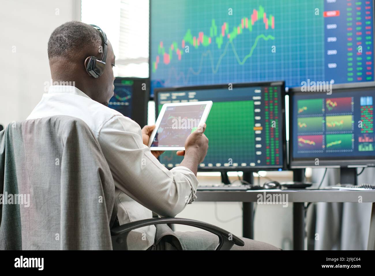 Young Black man holding digital tablet working with stock trading stats ...