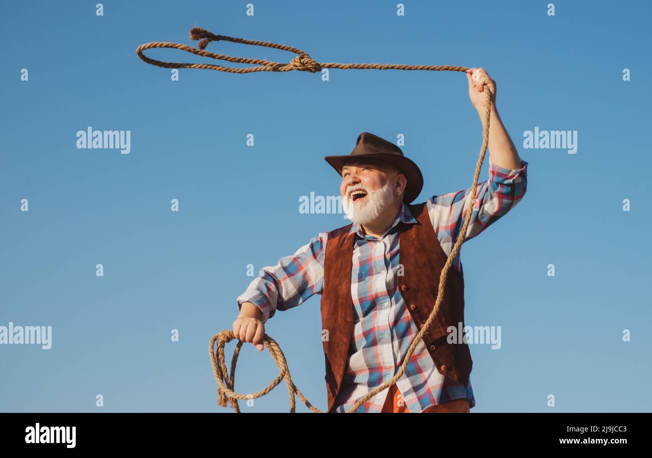 Old wild west cowboy with rope. Bearded western man throwing lasso with ...