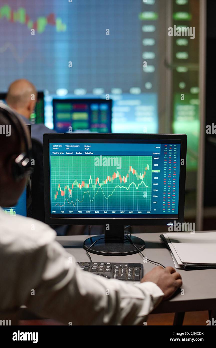 Rear view of unrecognizable African American man sitting in front of ...