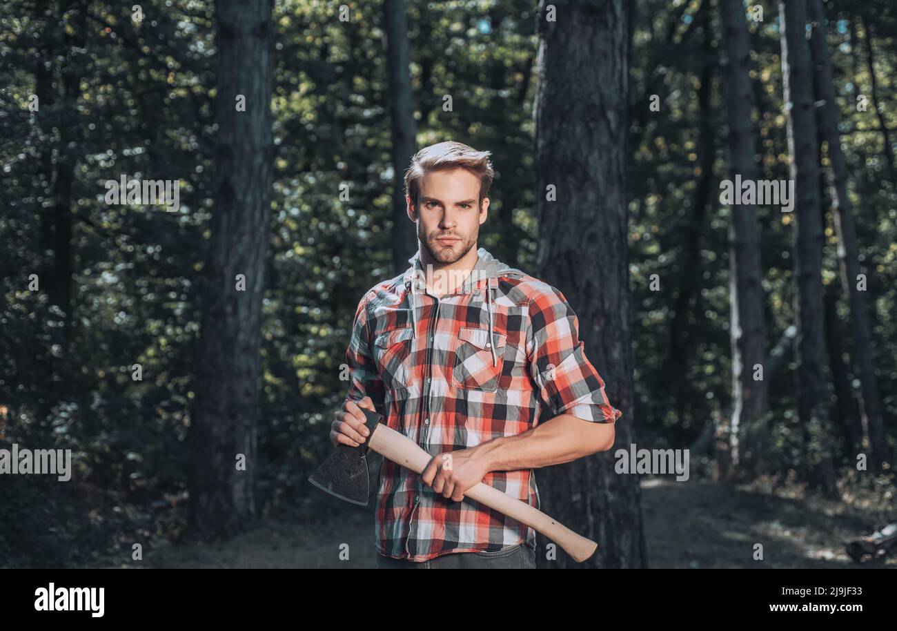 A handsome young man with a beard carries a tree. Stylish young man ...