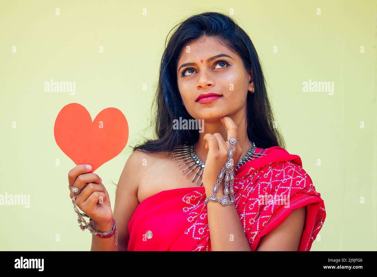 Beautiful indian woman in green saree holding a paper heart greeting ...