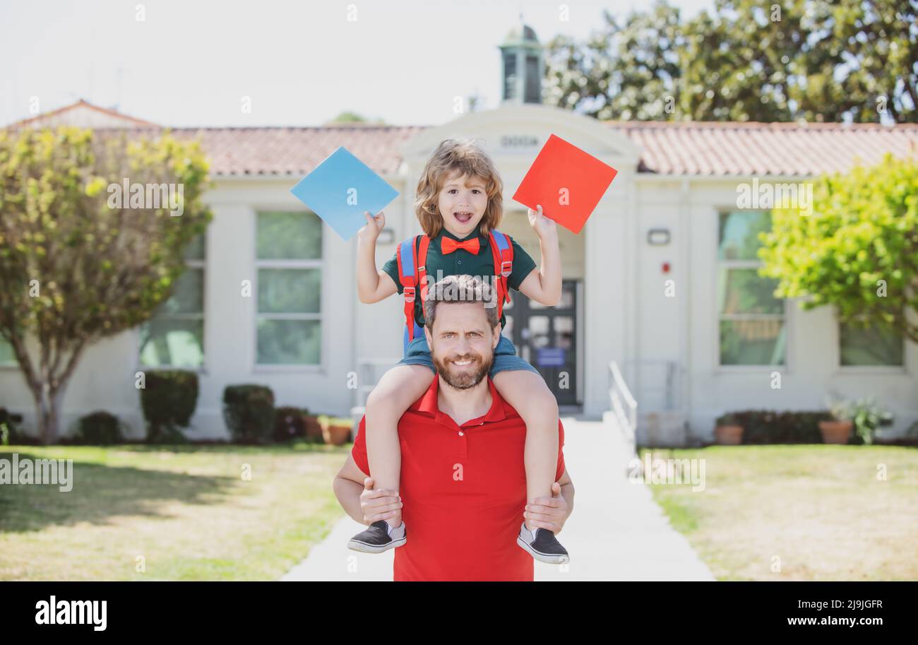 Parent and pupil of primary school go hand in hand. Father giving son ...