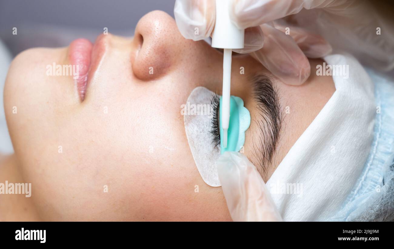 Young woman undergoing eyelash tinting and lamination procedure Stock ...