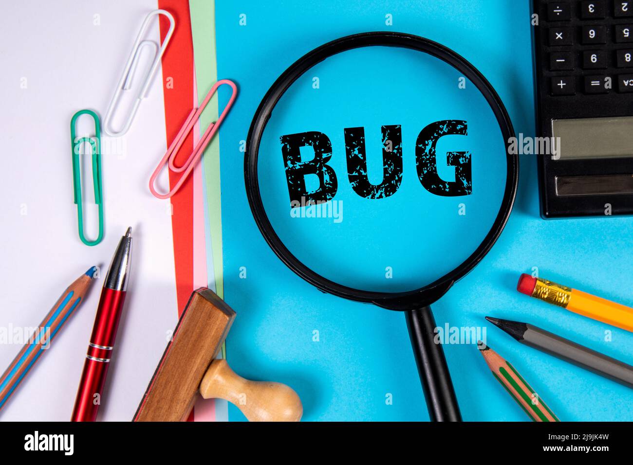 BUG. Magnifying glass, calculator and pencils on the office desk Stock ...
