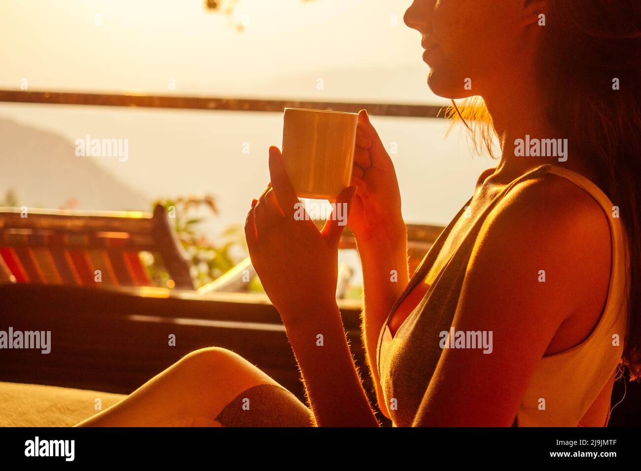 Beautiful woman with cup of coffee tea enjoying the view from the ...