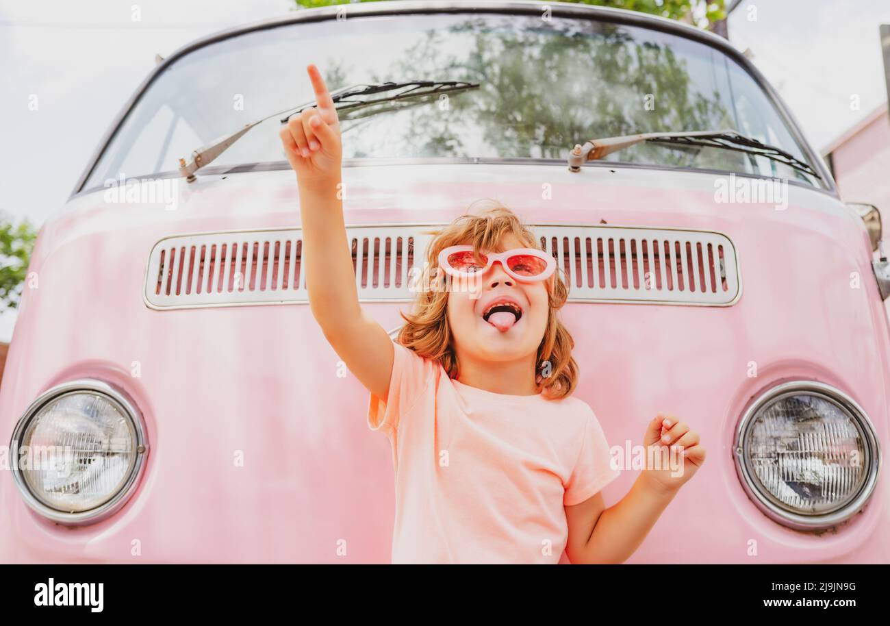Happy child in pink retro car. Kid hippie. Happy toddler child having ...