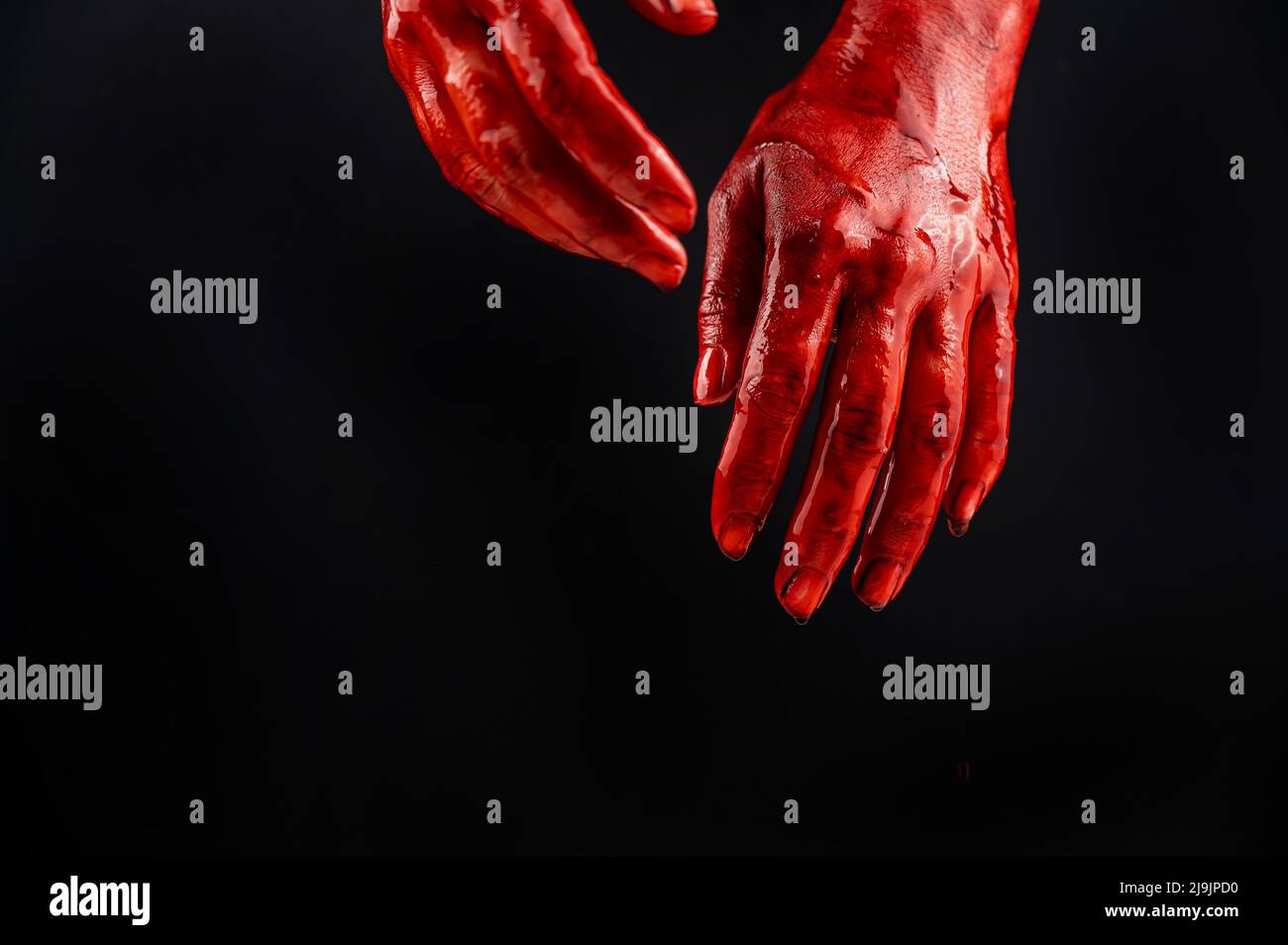 Women's hands in blood on a black background Stock Photo - Alamy