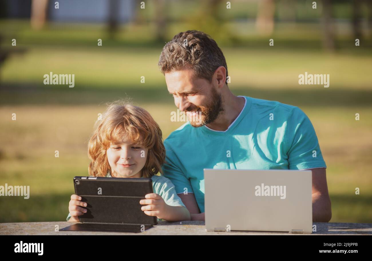 Happy father using laptop relax with schooler son holding laptop have ...