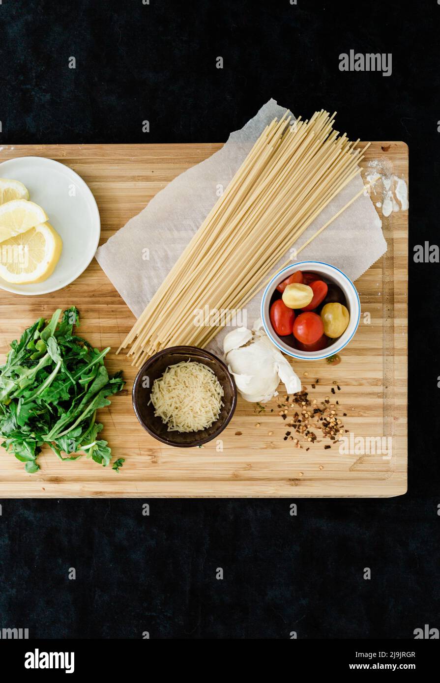 Spaghetti pasta on a wooden dinner table with white plates and napkins ...
