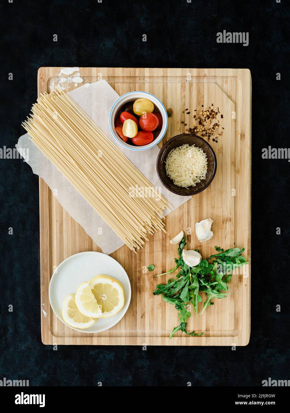 Spaghetti pasta on a wooden dinner table with white plates and napkins ...
