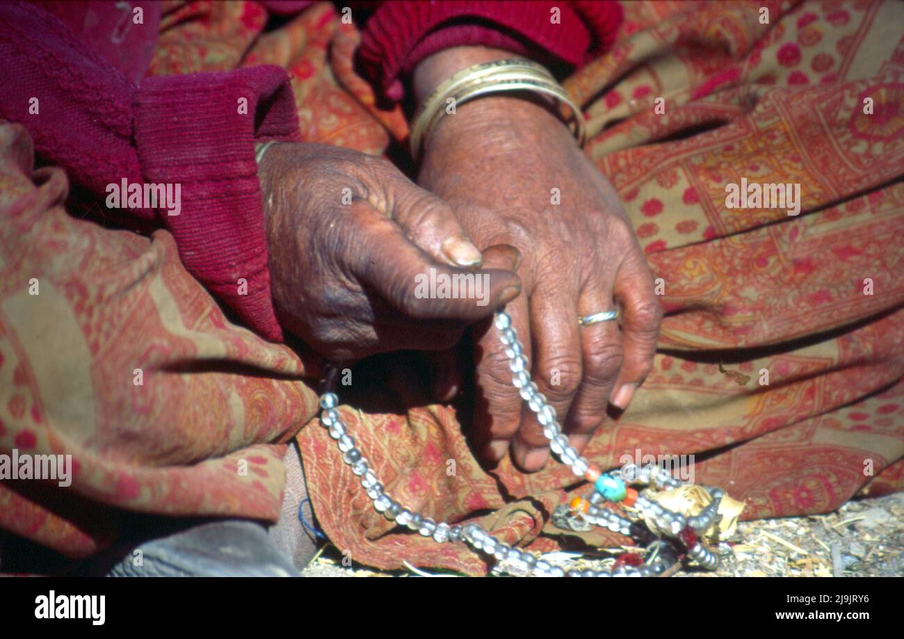 Hands holding mala prayer beads used by Buddhists Stock Photo - Alamy