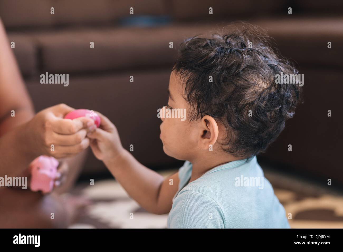child receiving toy in the hand that his mother is giving him Stock ...