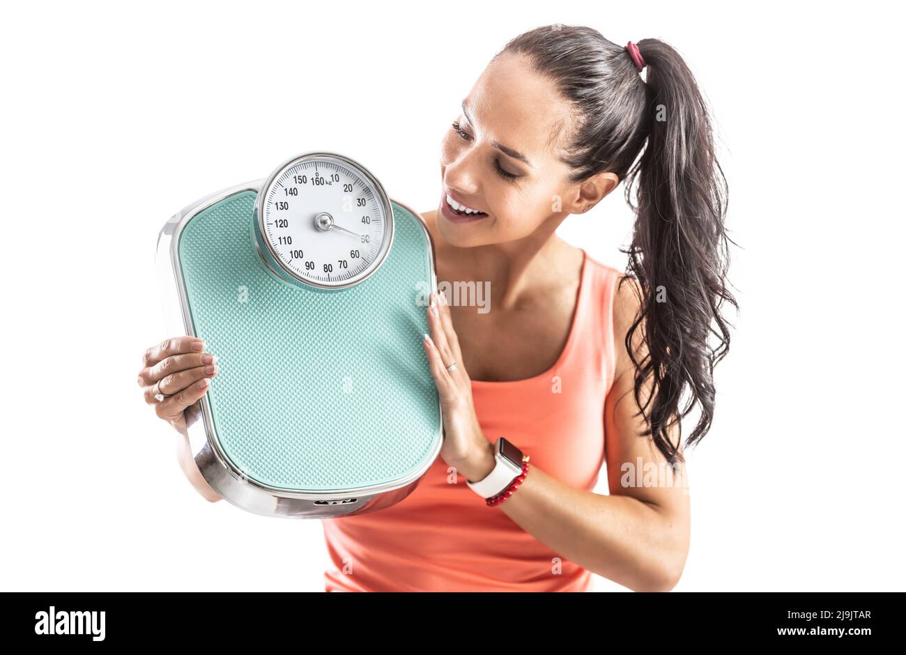 Good-looking slim brunette holds and oldschool scale in her hands ...