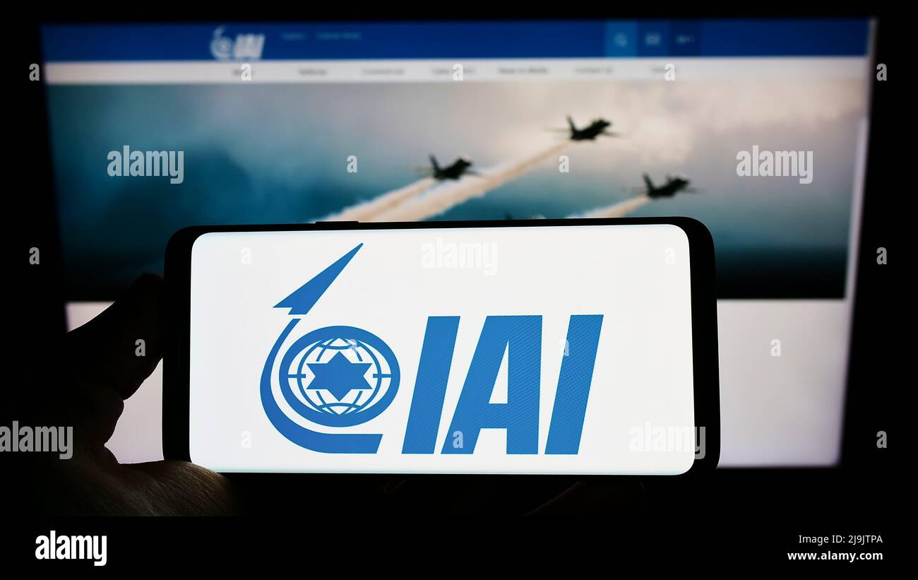 Person holding mobile phone with logo of company Israel Aerospace ...